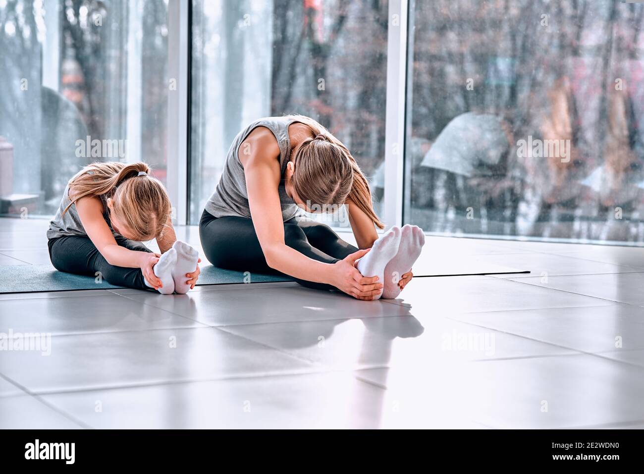 Sporty mother and daughter. Front view of athletic young woman and her ...