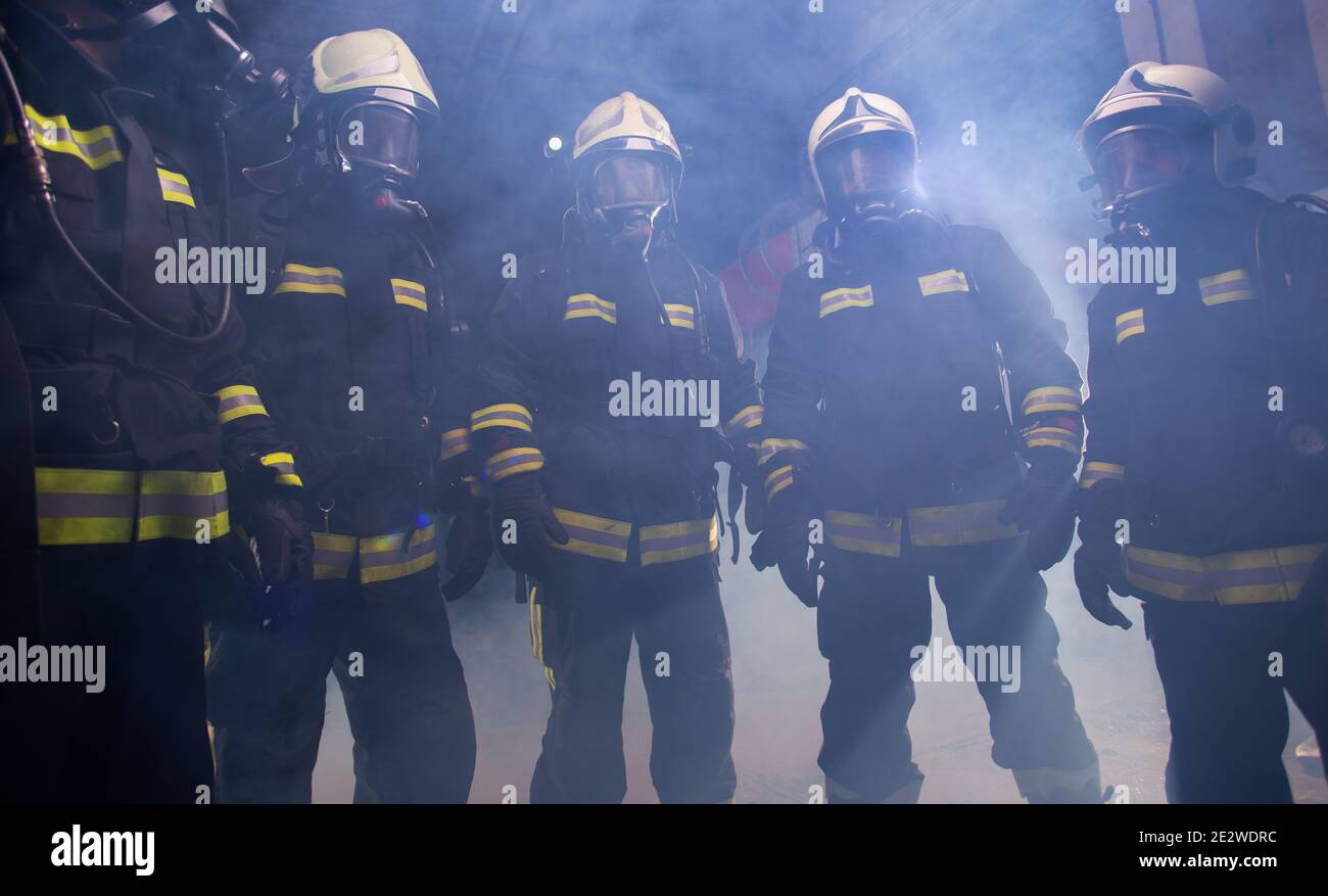 Portrait of group of firefighters in the middle of the smoke of the ...