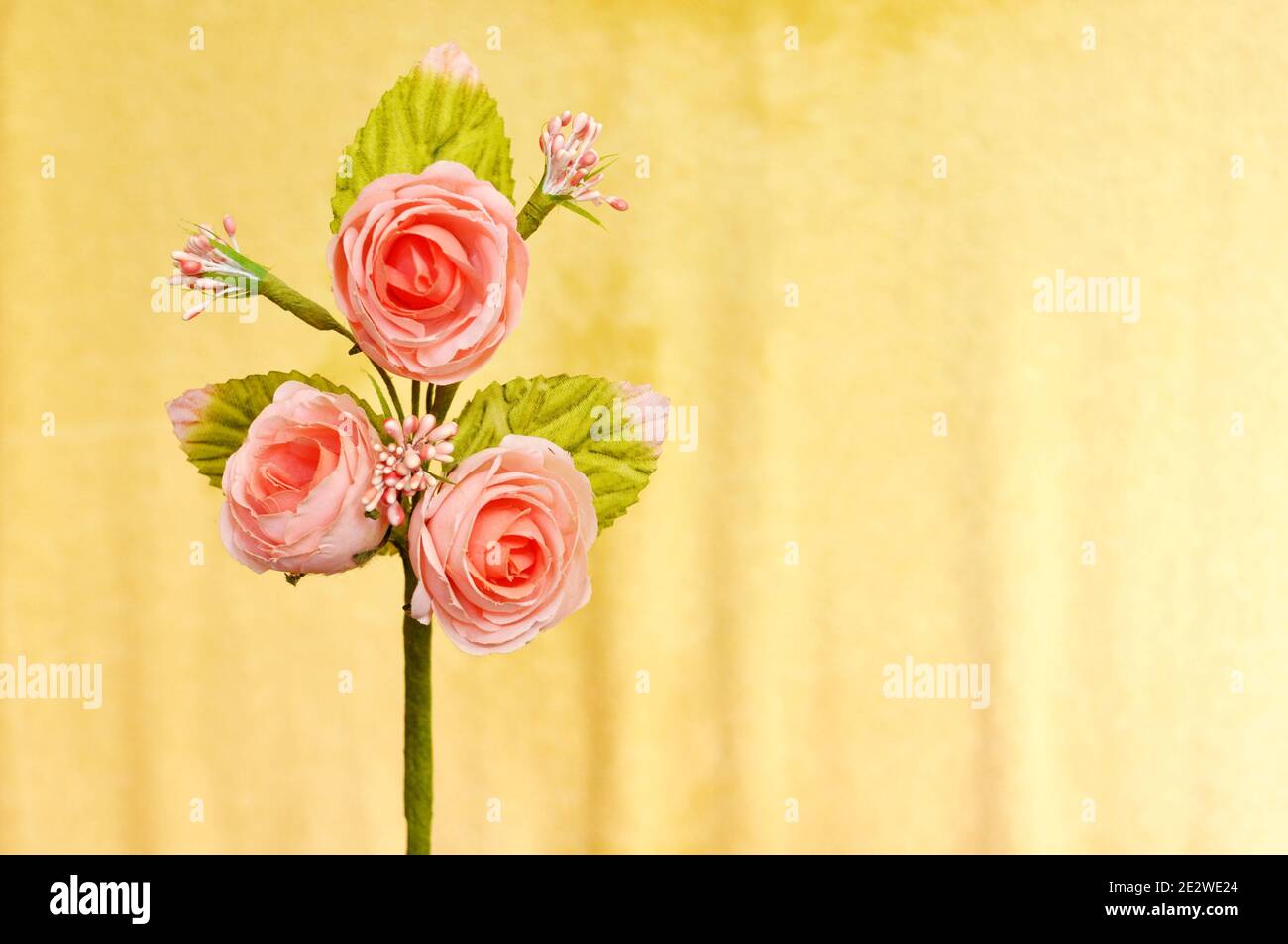 Artificial pink roses on yellow background Stock Photo - Alamy
