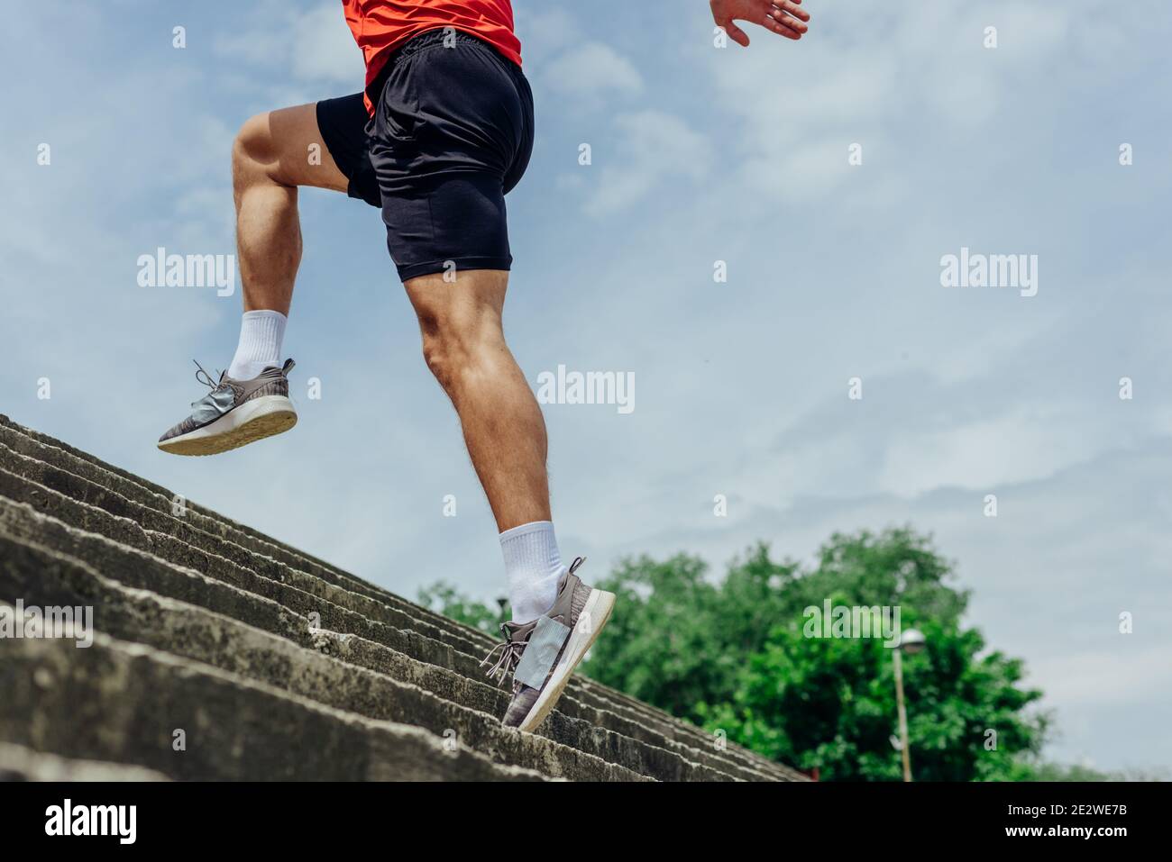 Fit male athlete performing stairs workout, running up climbing stairs ...