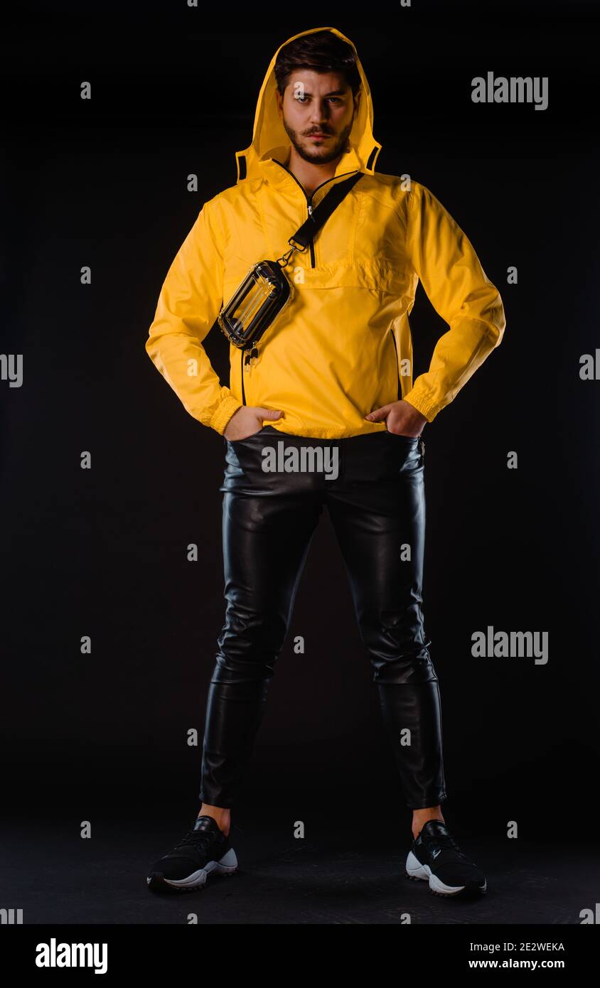 Portrait of a trendy guy wearing yellow jacket and black pants Stock ...