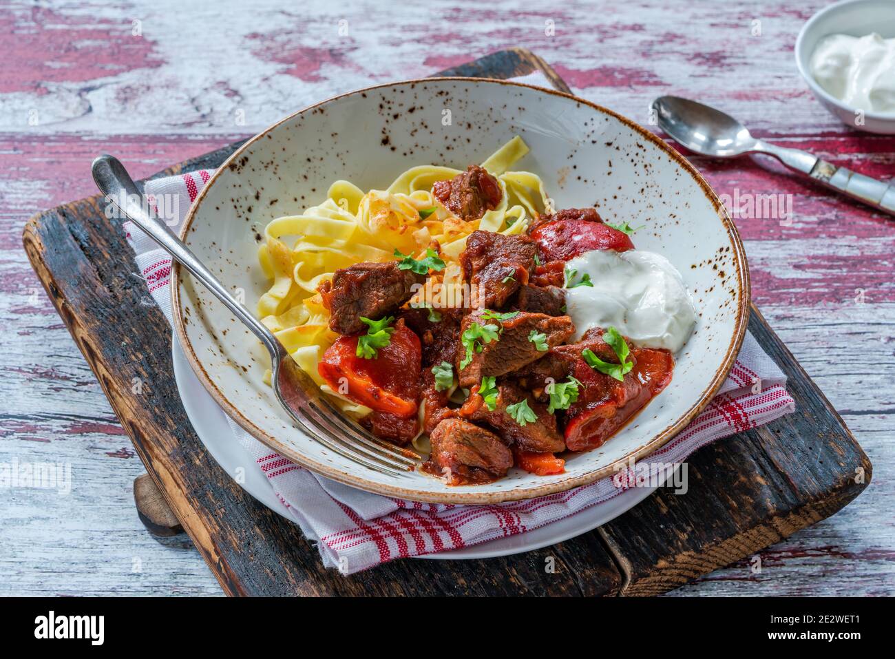 Venison goulash with tagliatelle pasta and soured cream Stock Photo - Alamy