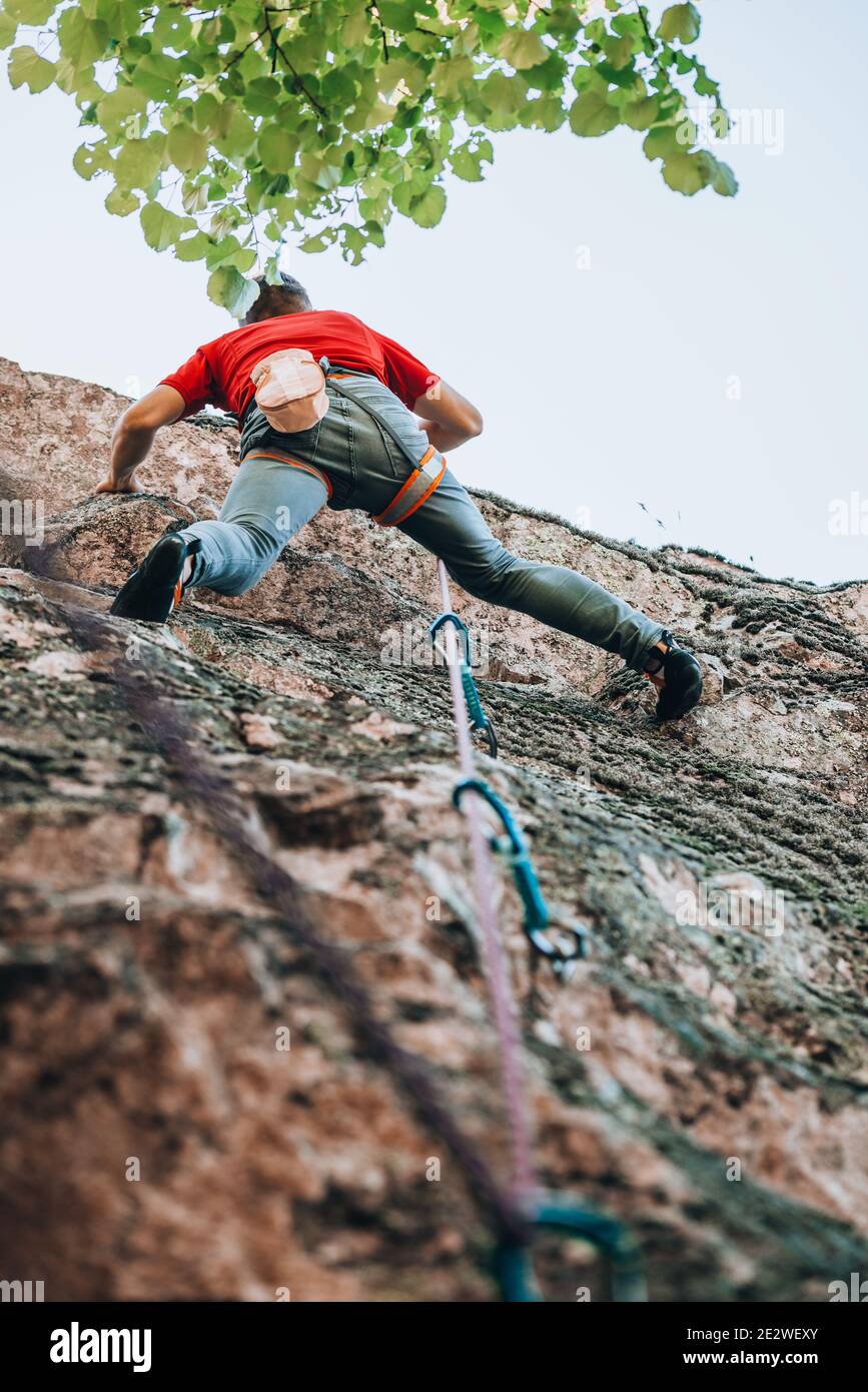 Climber with climbing equipment hanging on a rope and falling down an ...