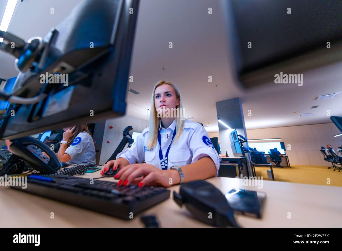 Female security operator working in a security data control room ...