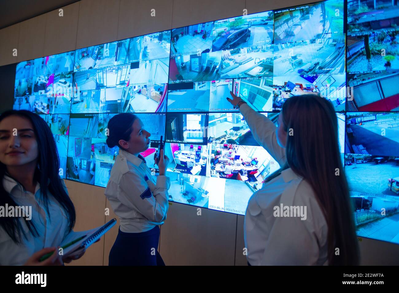 Security guards standing in front of a large CCTV monitor at the main ...
