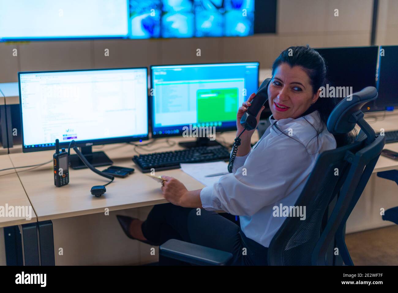 Happy security data center operator colleagues (coworkers) smiling and ...