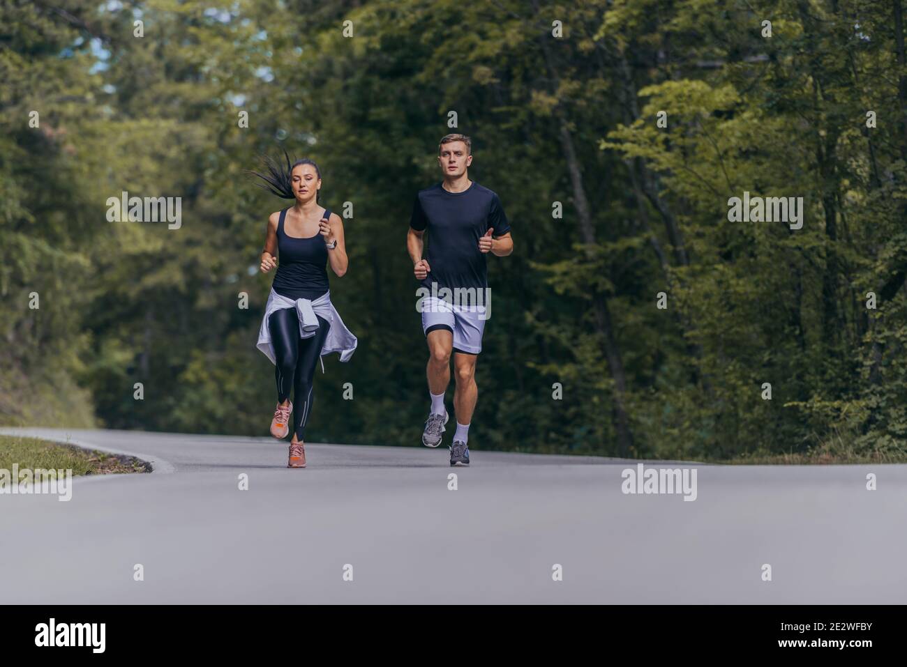 Athletic couple running on a street next to each other. Nature,fit and ...