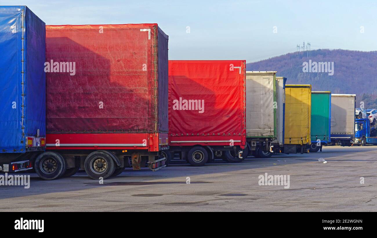 Many big trucks with cargo trailers parked at depot Stock Photo - Alamy