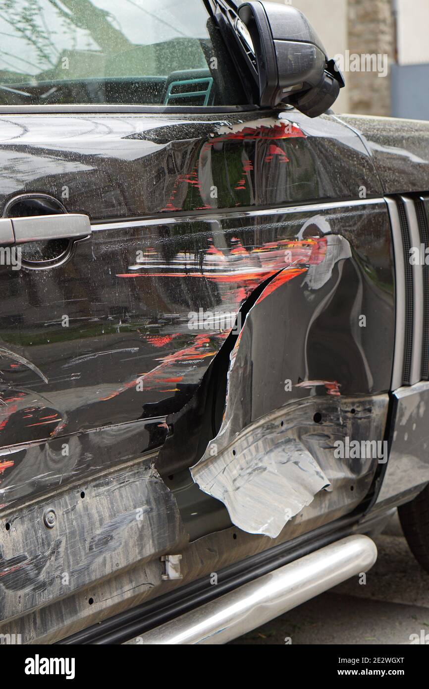 Big hole and dent at suv door crash damage Stock Photo - Alamy