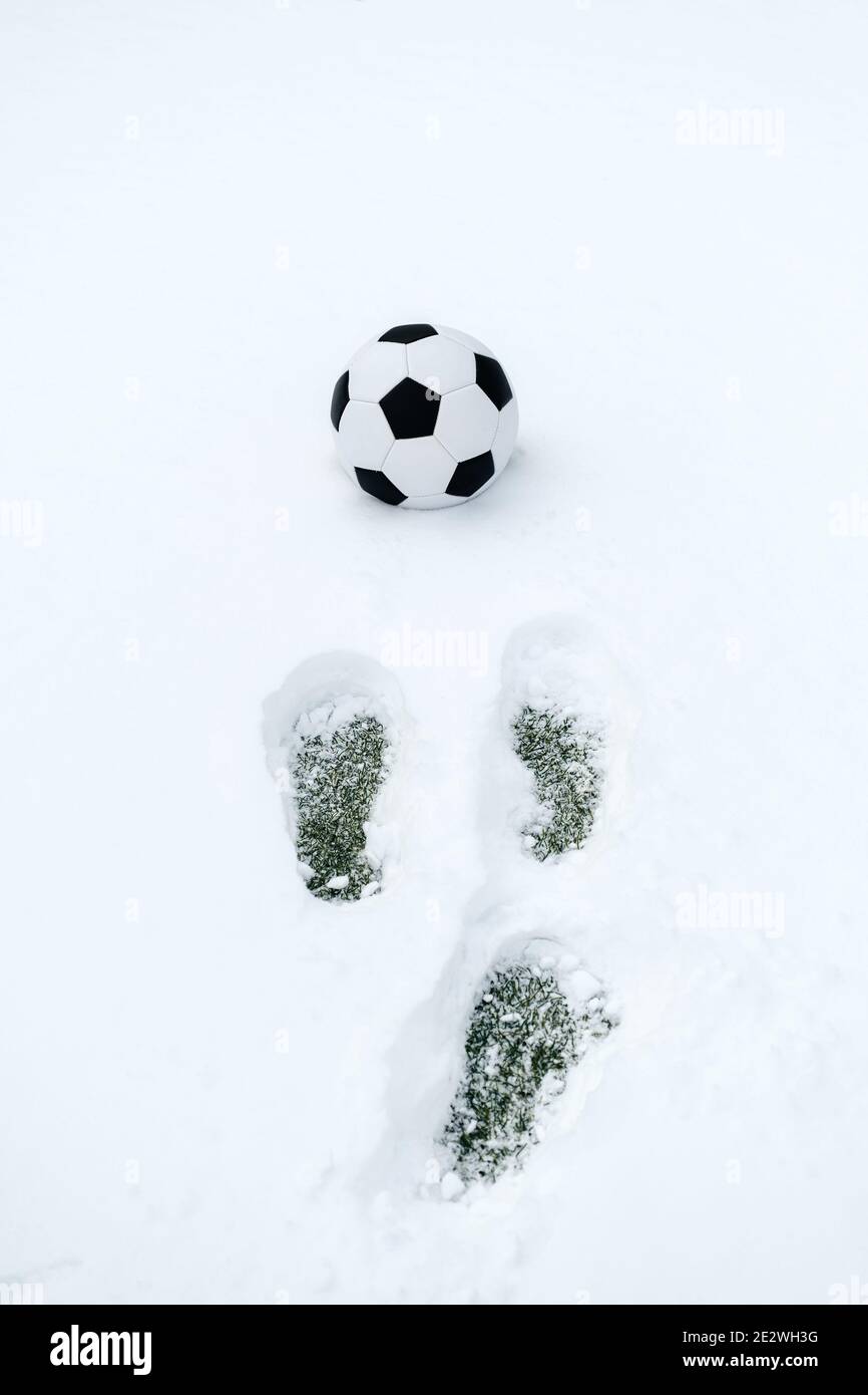 Soccer ball on a snowy sports field and footprints in the snow Stock ...