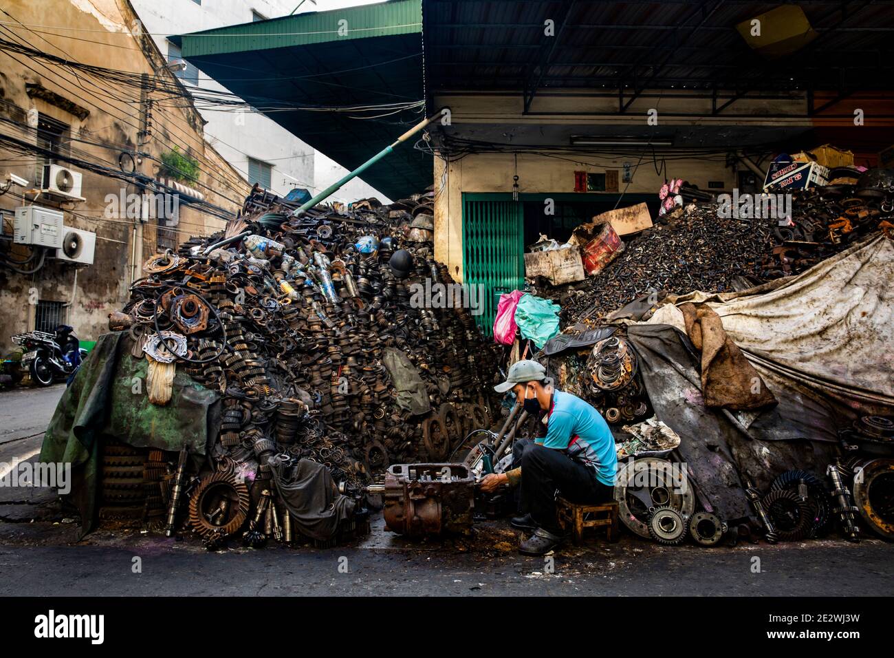 Young Mechanic works on Auto Repair at Shop Crowded by Thousands Parts ...