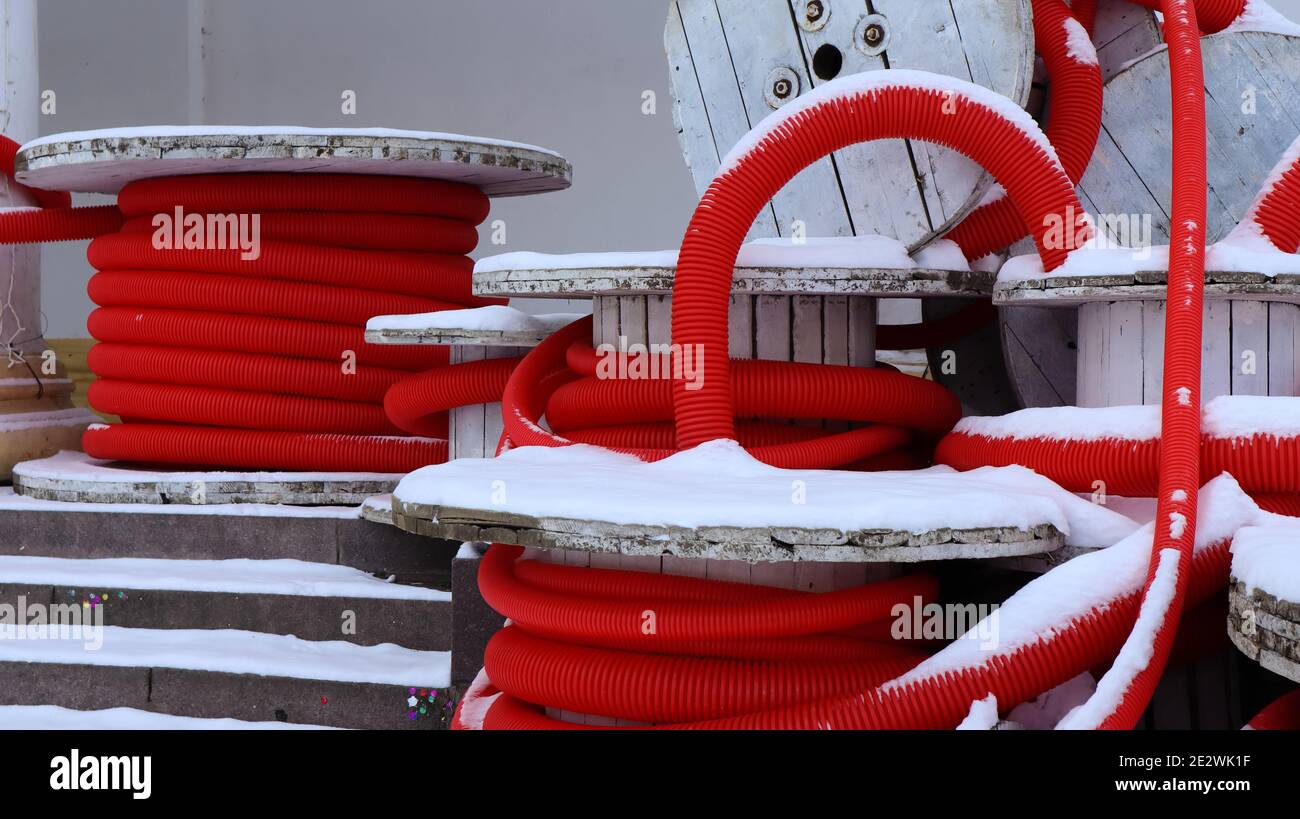 Large coils of red flexible corrugated pipe used to protect cables in ...