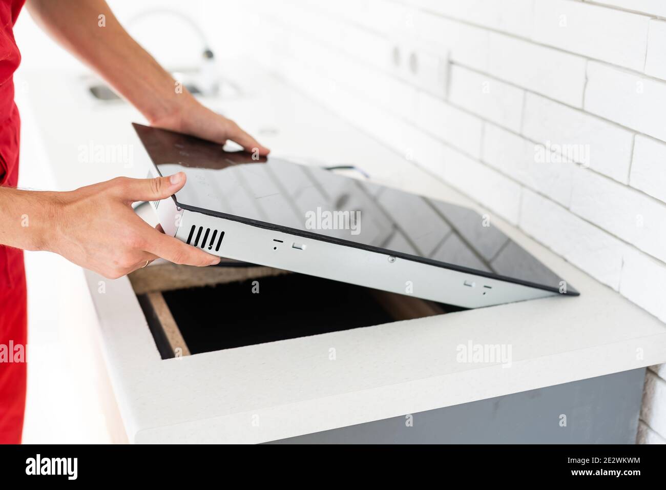 Installation of induction stove or cooktop by a master Stock Photo - Alamy