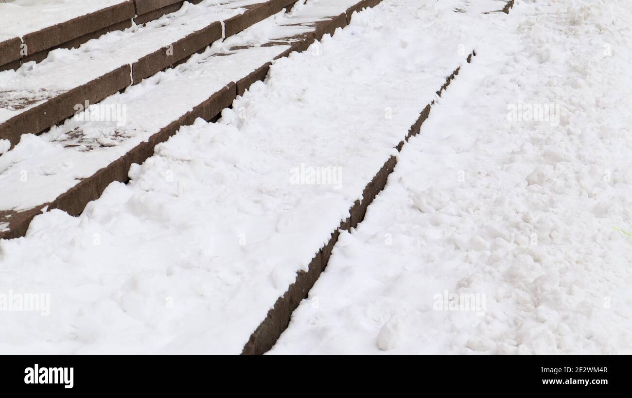 Snow covered slippery concrete stairs. First snow on granite stone ...