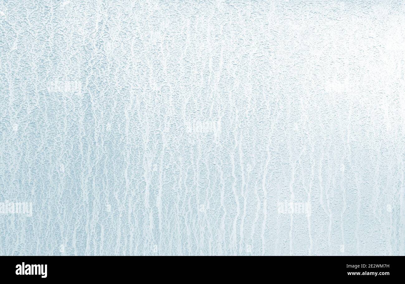 Frozen streams of water with a blue tinge on the glass. The concept of ...