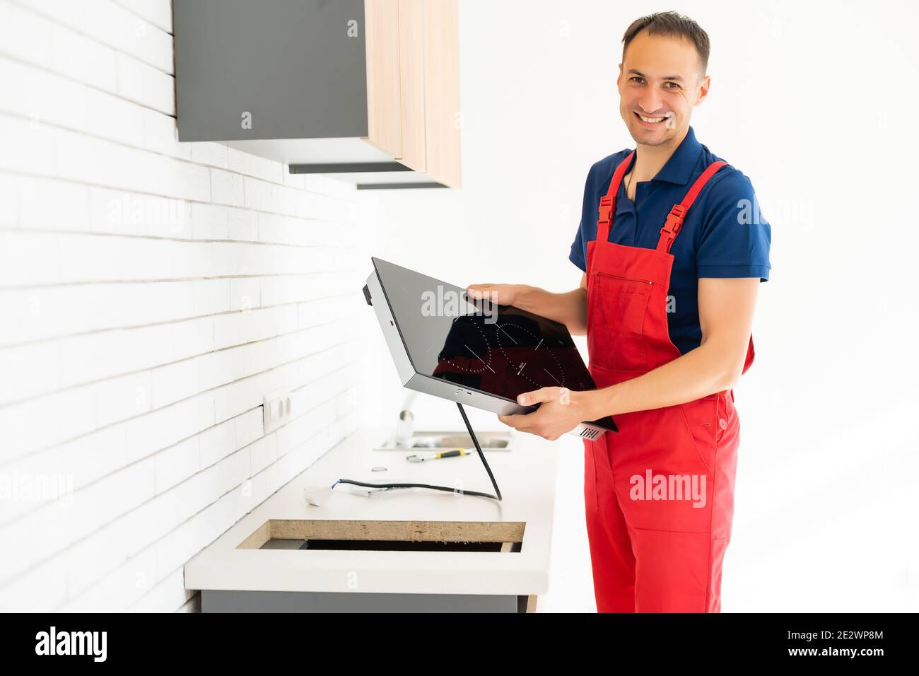 Installation of induction stove or cooktop by a master Stock Photo - Alamy