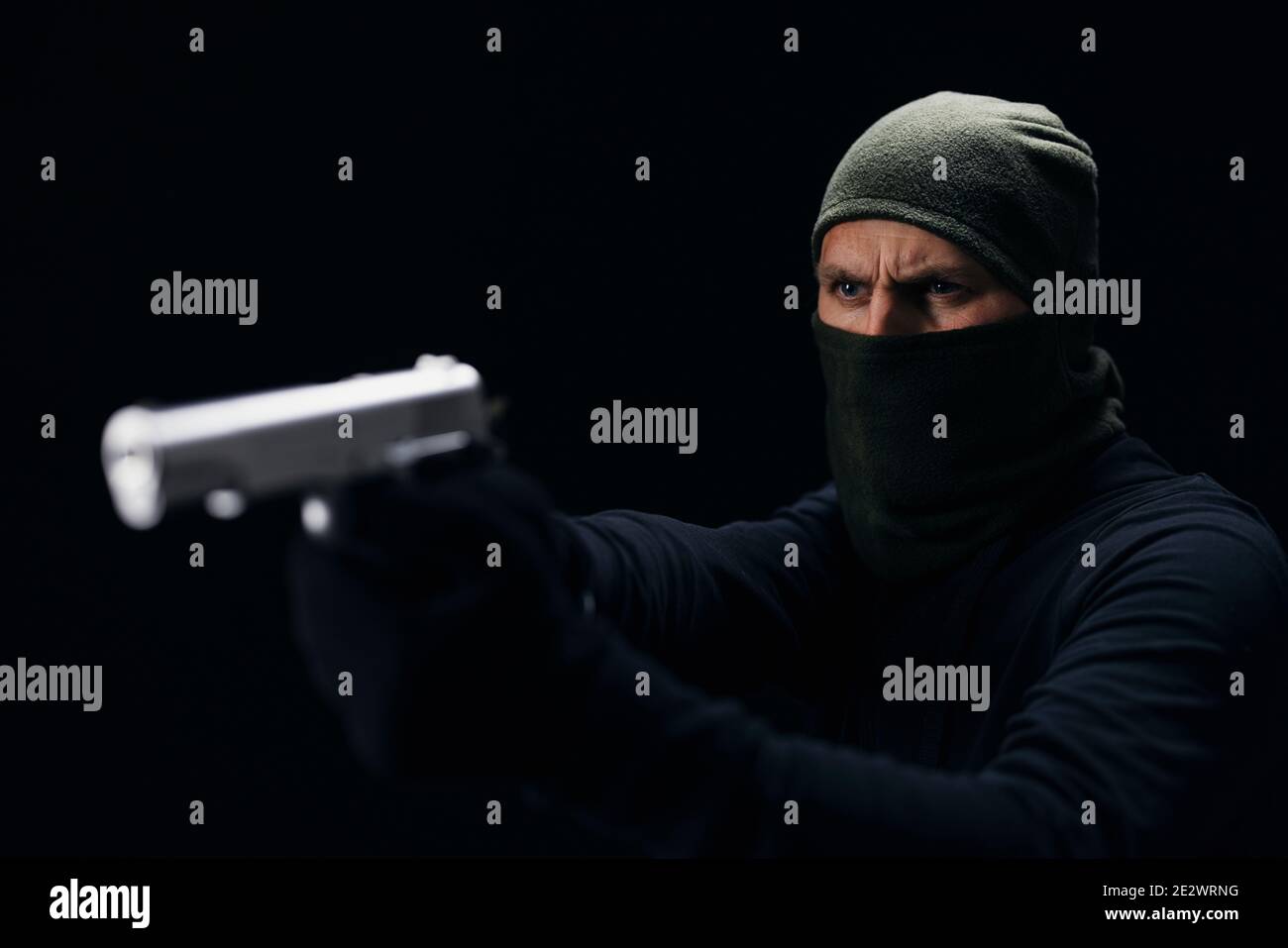 Dangerous offender aiming with real gun Stock Photo - Alamy