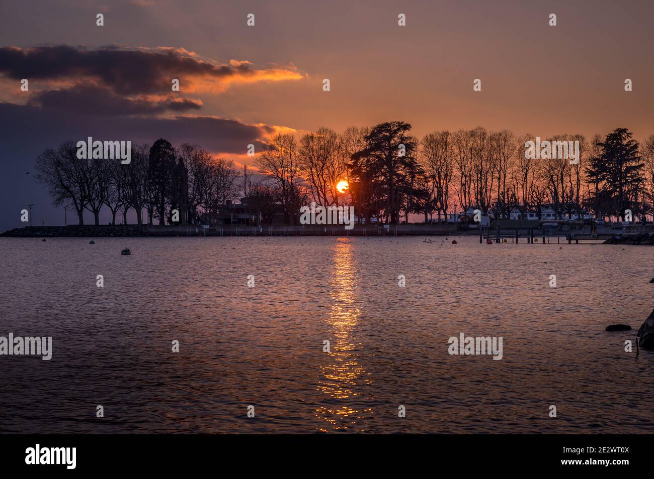 Sunset over lake with backgrounds of trees and clouds in Lausanne ...