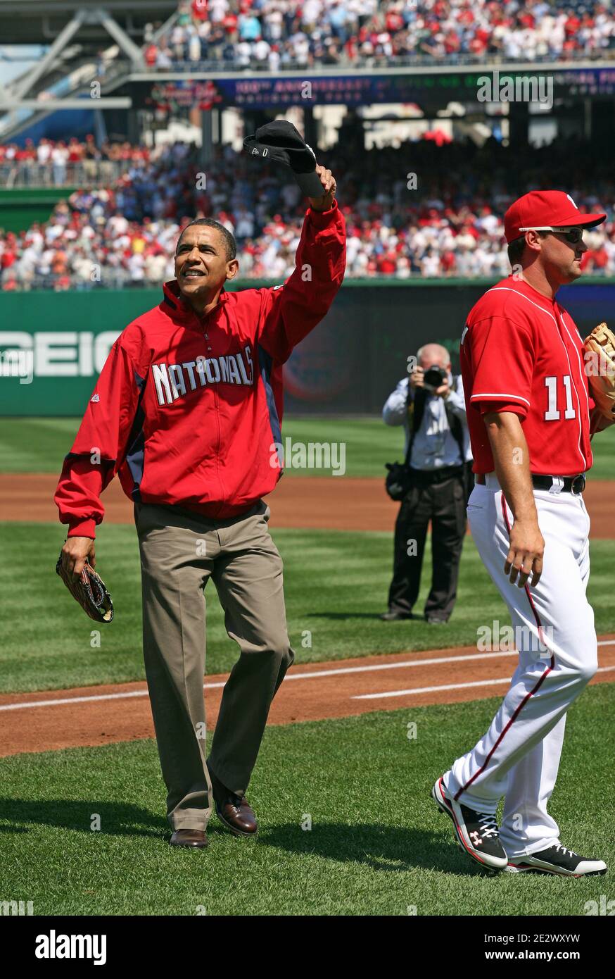 US President Barack Obama waves to the crowd after he threw out the ...