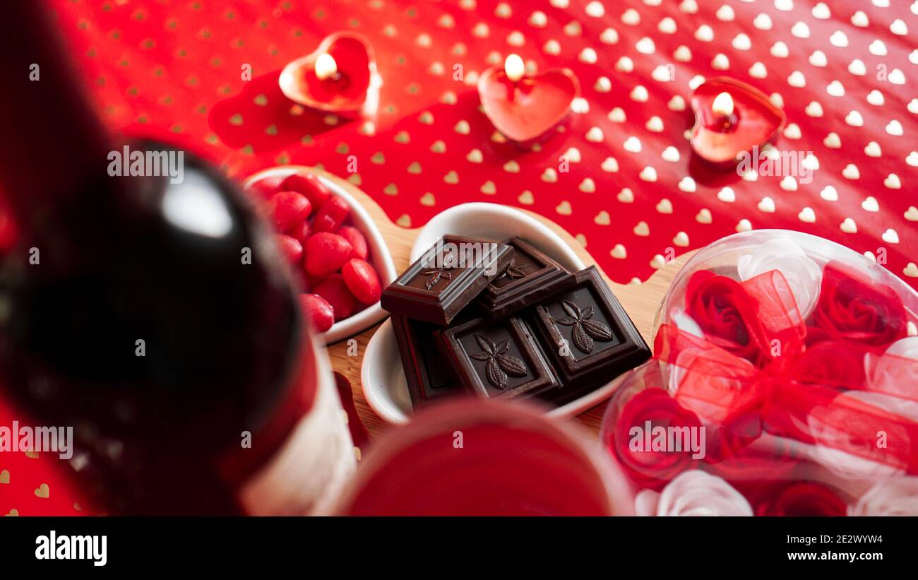 Chocolates and sweets on heart-shaped plates. Festive table setting for ...