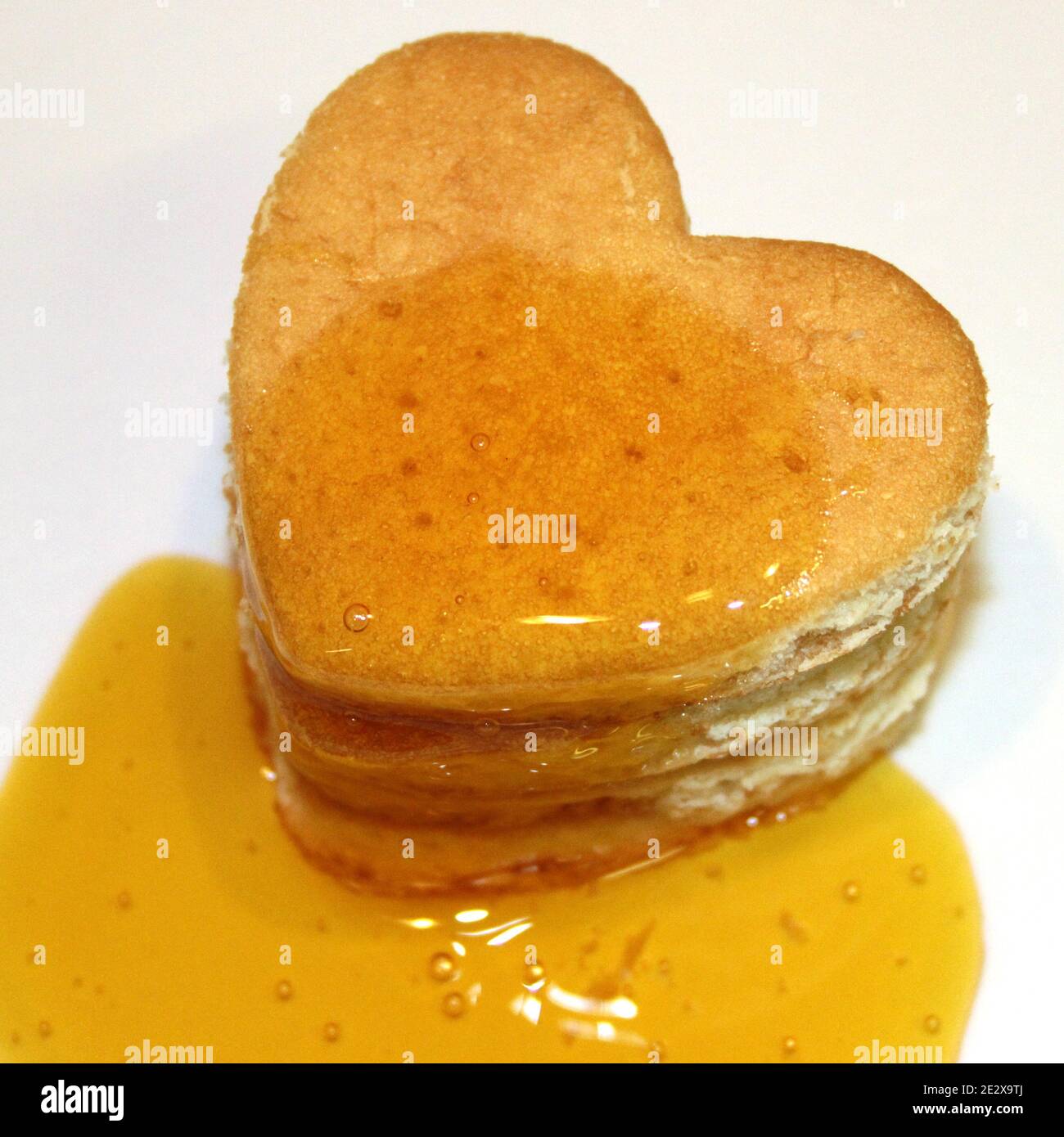 Pancakes in heart shape covered by honey Stock Photo - Alamy