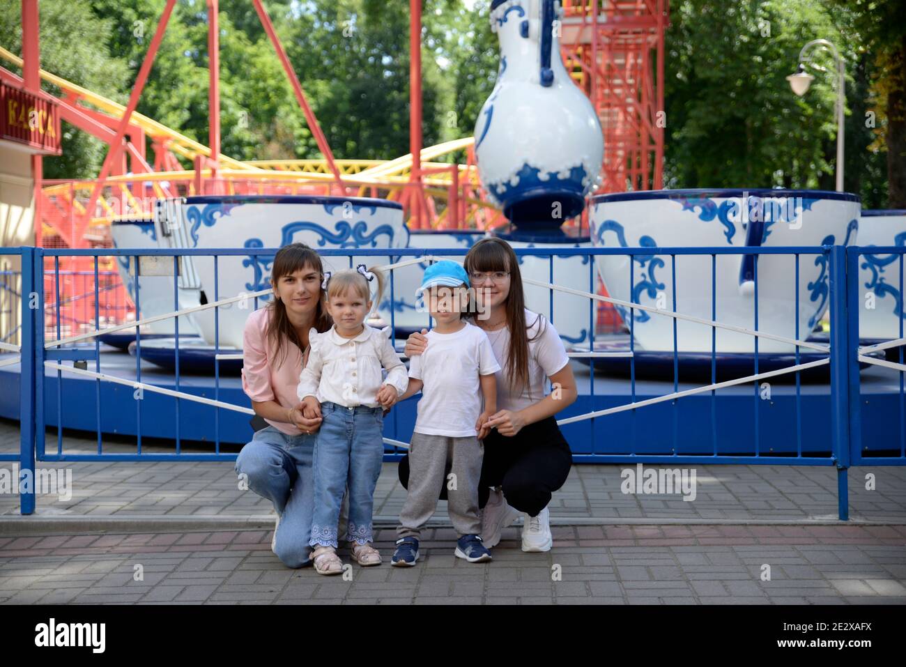 two families walk with children in a park near attractions Stock Photo ...