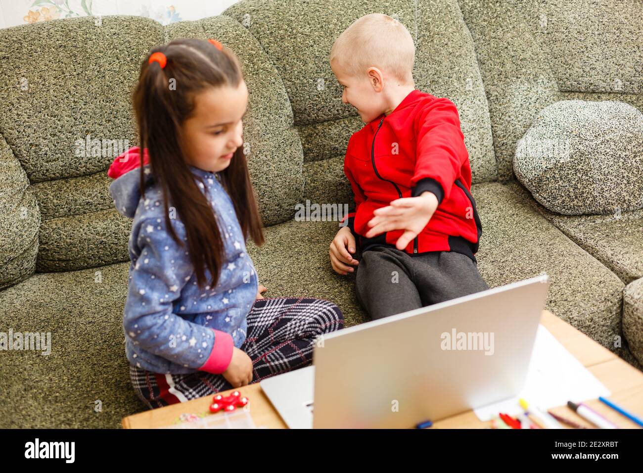 Two beautiful cute happy smiling children, a boy and a girl, use laptop ...
