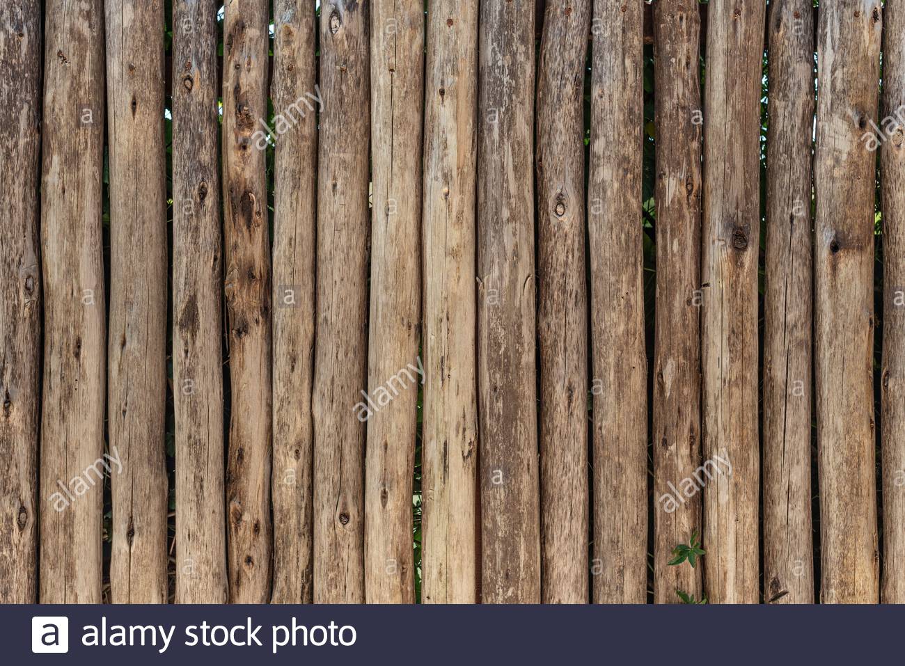 Old fence made of wooden logs. Tree trunk fence texture Stock Photo - Alamy