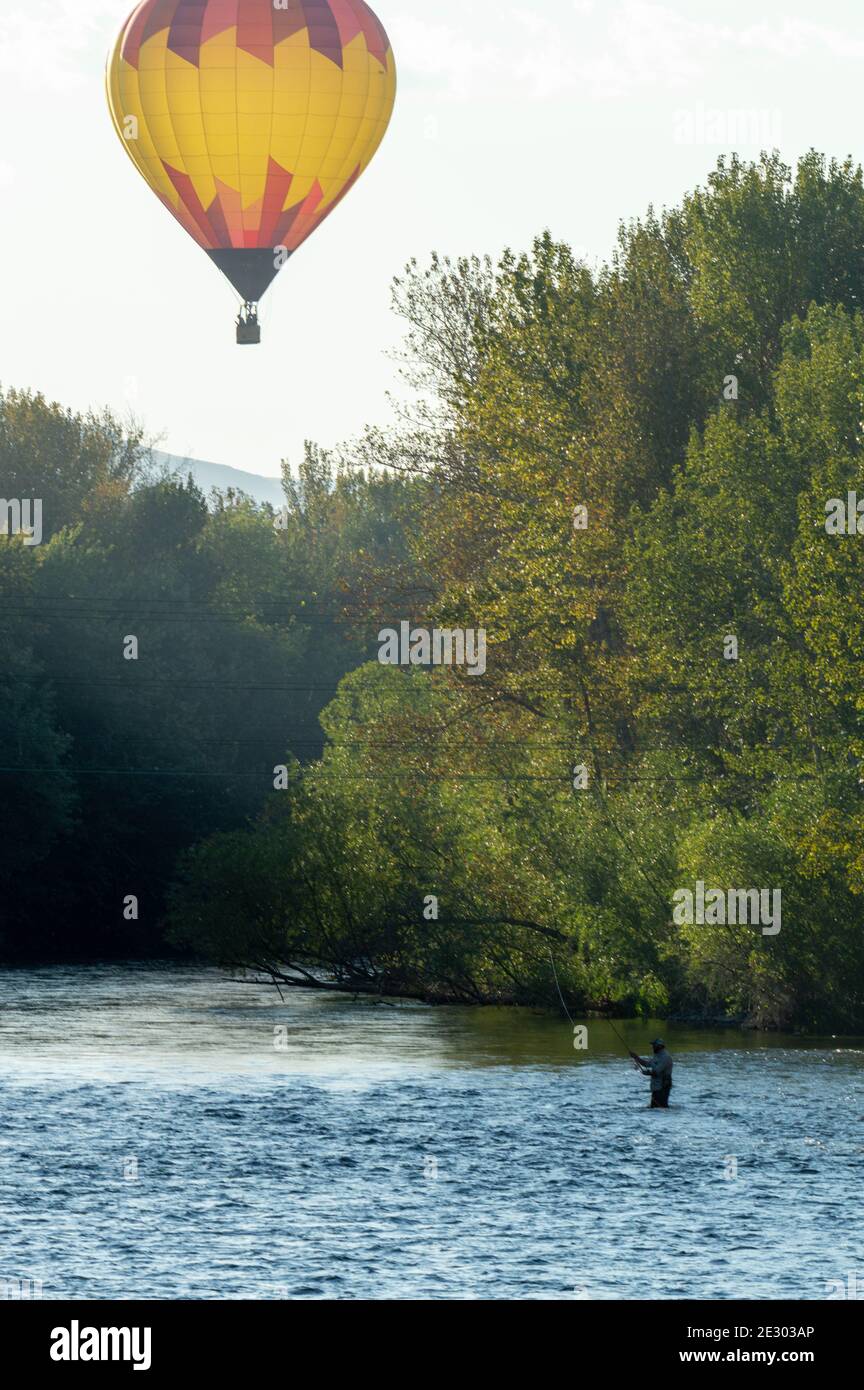 Balloon flies over Boise river fisherman Stock Photo - Alamy