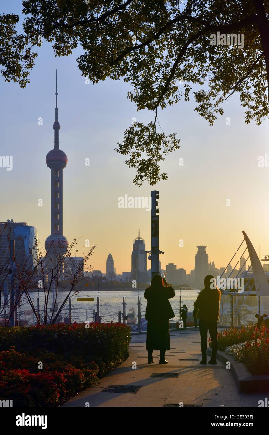 Taking photographs and watching the sunset looking across to the Pudong ...