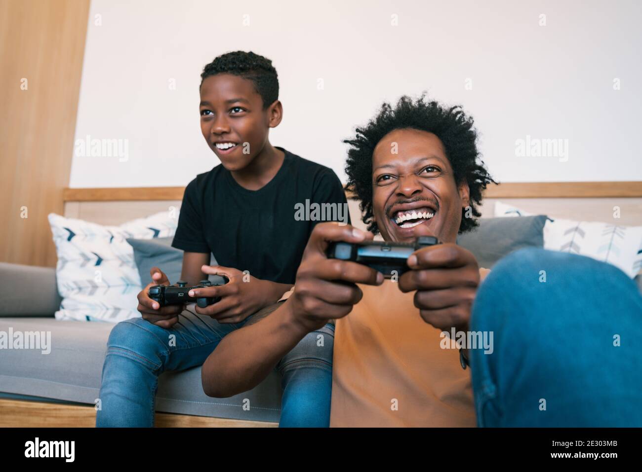 Father and son playing video games together at home Stock Photo - Alamy