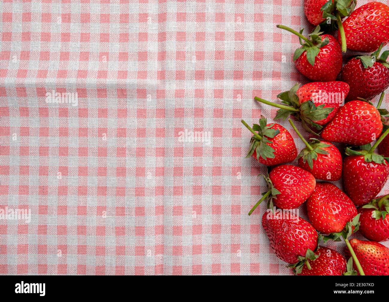 Fresh strawberries on Pink plaid fabric background. vegan food ...