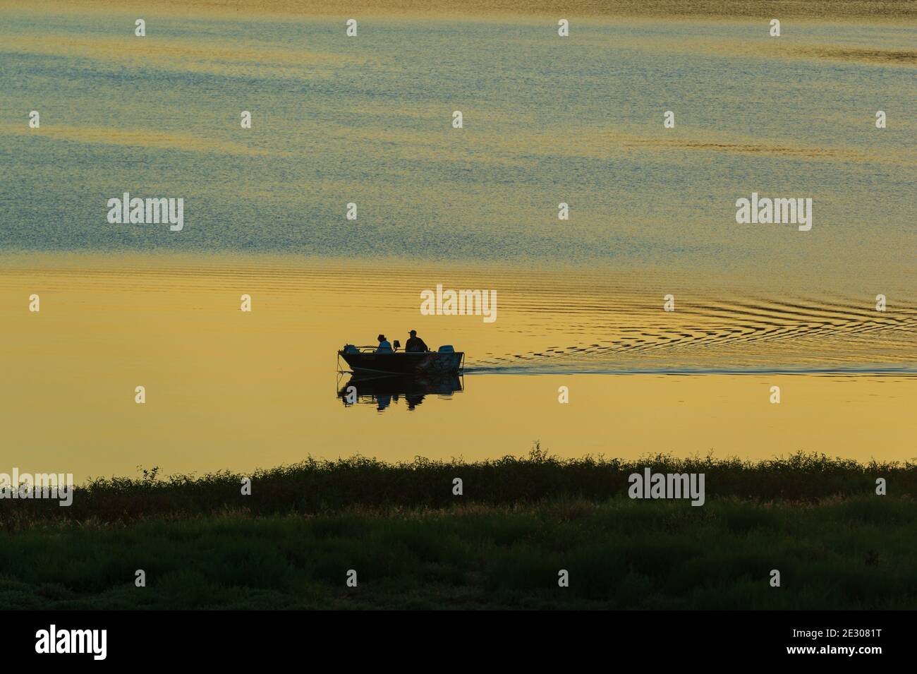 Ripples in the water behind a boat on Lake Callide at sunrise, Biloela ...