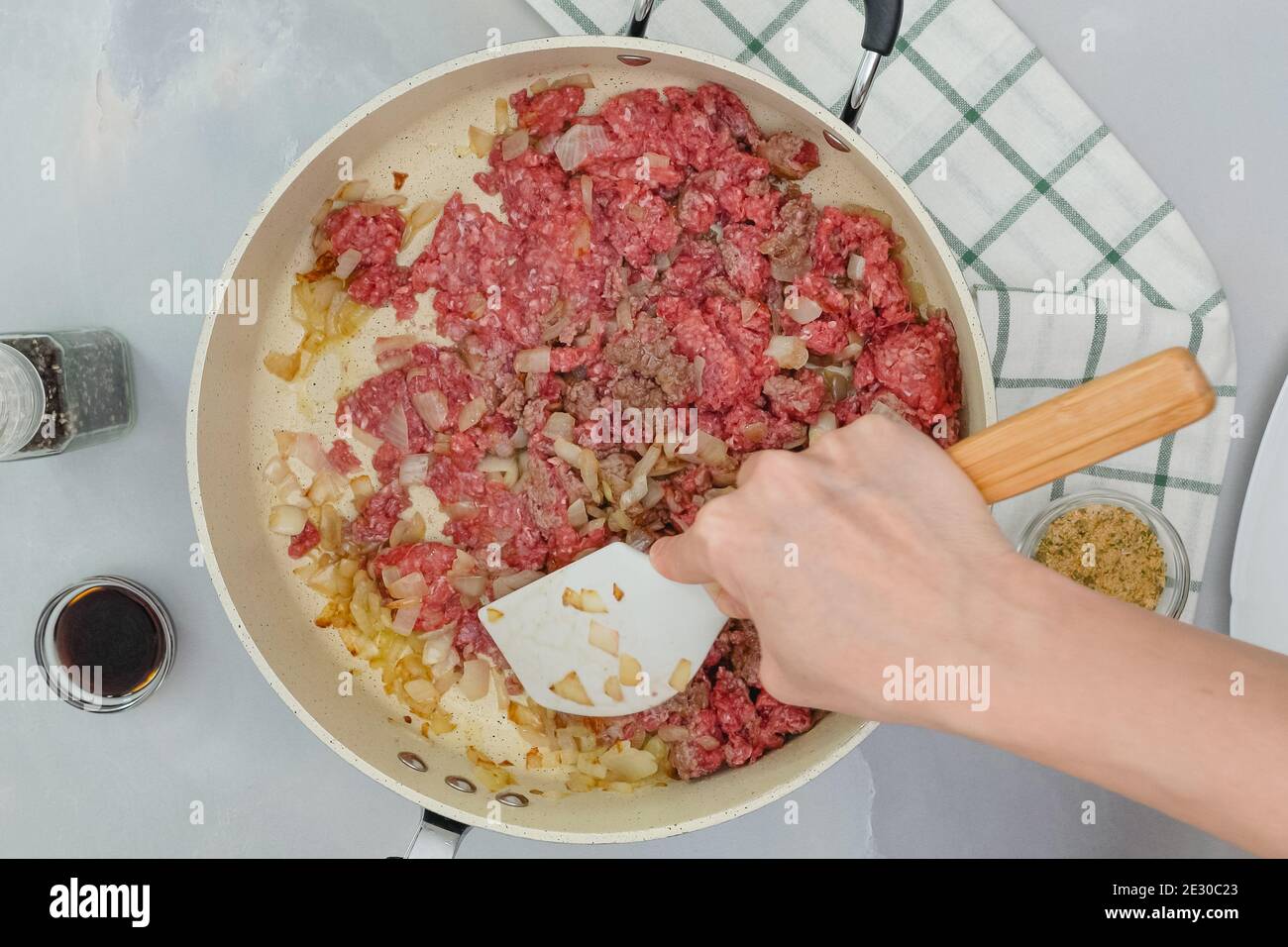 Ground beef and chopped onion. Chef mixing raw ingredients on frying ...