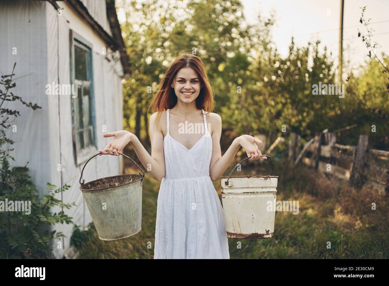 how was it a happy woman with buckets near a building in a nature farm ...