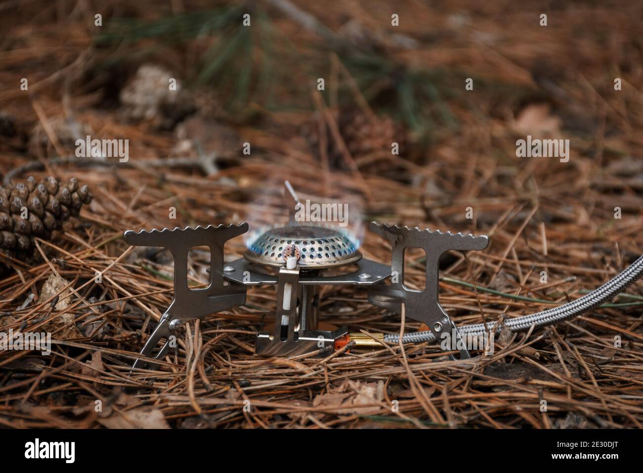 Tourist gas burner for heating food. Open fire close-up. Metal portable ...