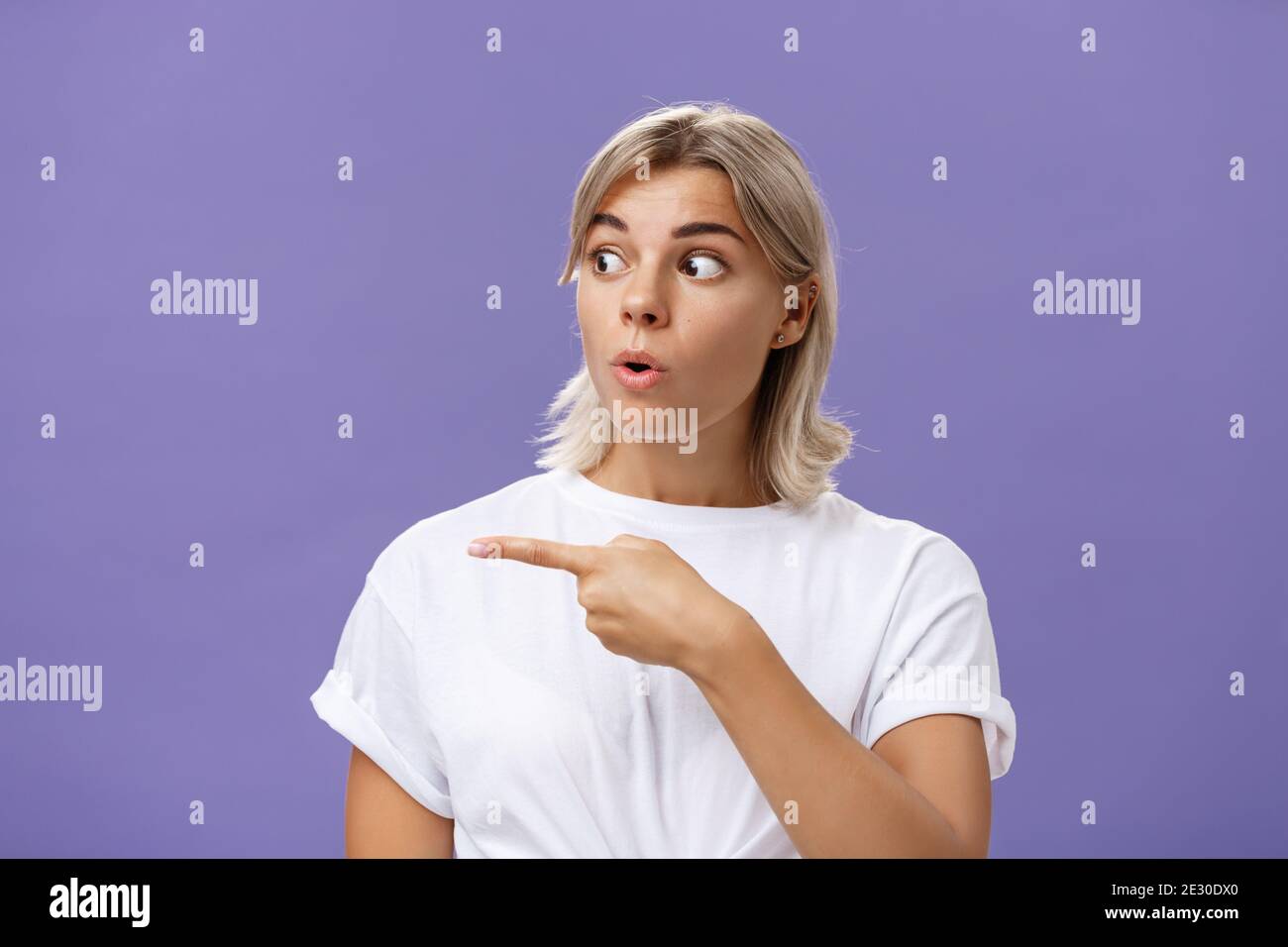 Close-up shot of intrigued interested attractive adult blonde female in ...