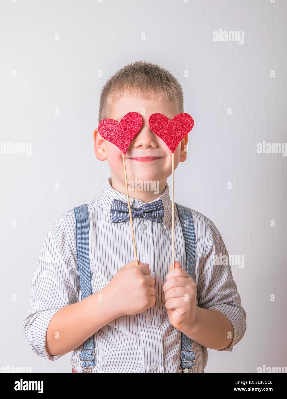Five year old smiling boy holding a red heart on eays symbol of love ...