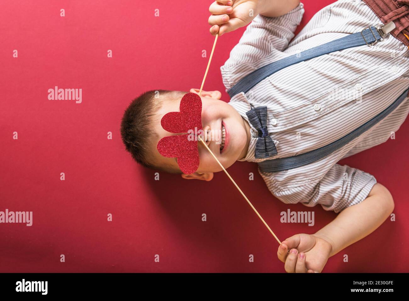 Five year old smiling boy holding a red heart on eays symbol of love ...