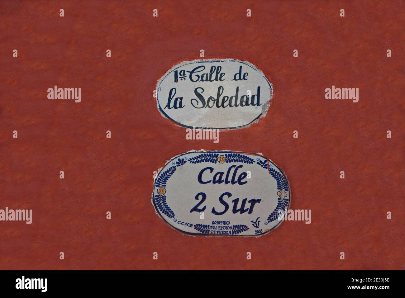 Handcrafted Talavera glazed ceramic street signs on a Venetian red ...