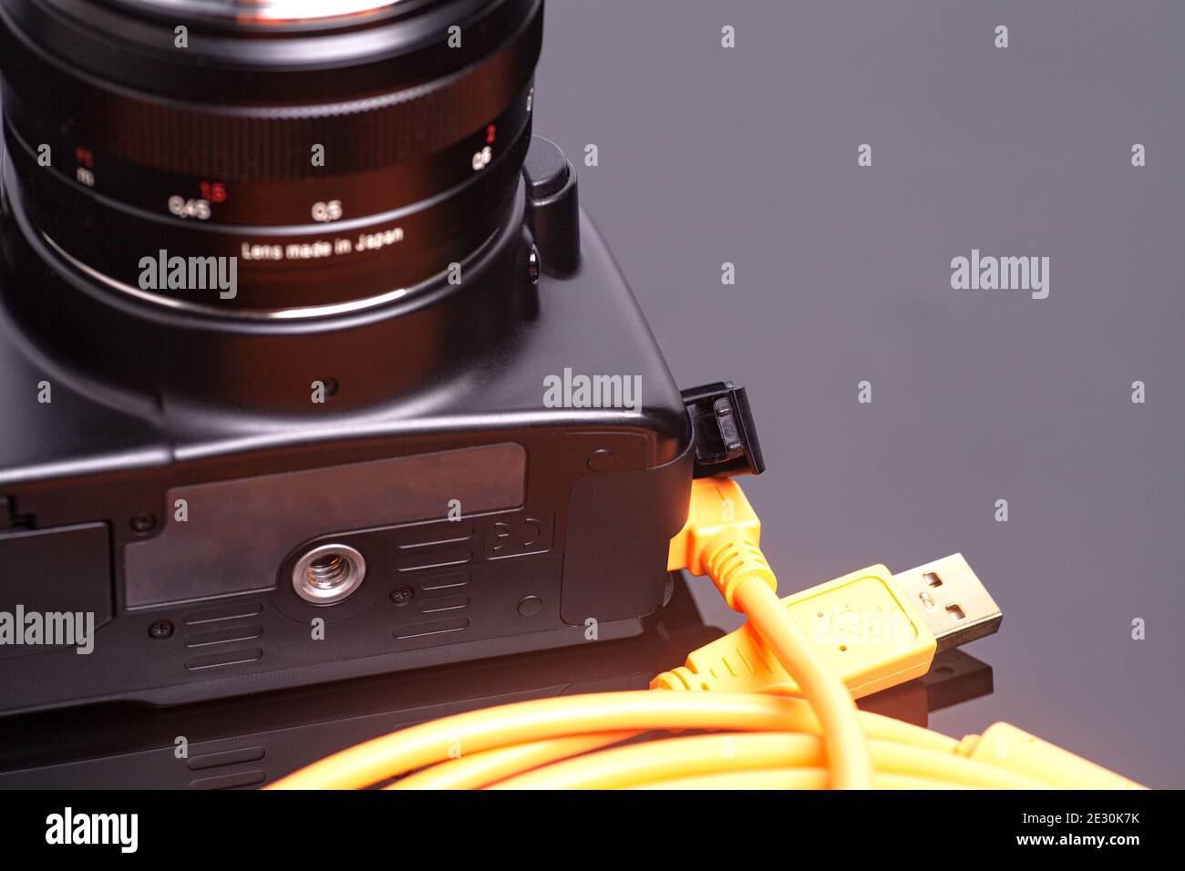 Digital photo camera with orange rolled cable Stock Photo - Alamy