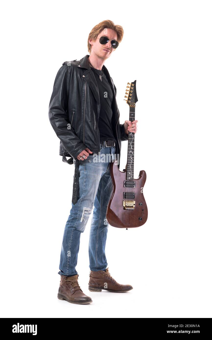 Cool assertive male guitarist standing with electric guitar in stylish ...