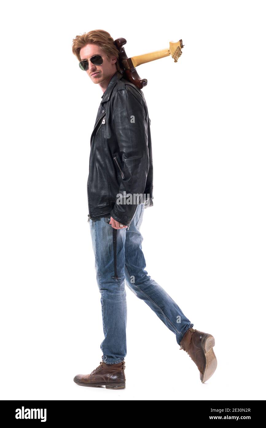 Side view of confident macho rocker man with sunglasses carrying ...