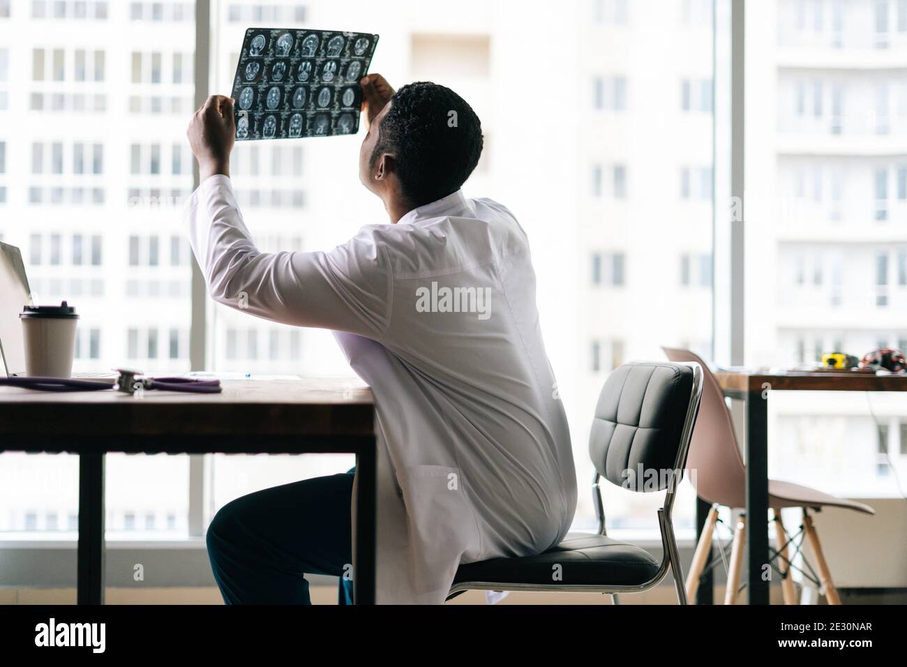 African American black man doctor looking at MRI brain scan image while ...