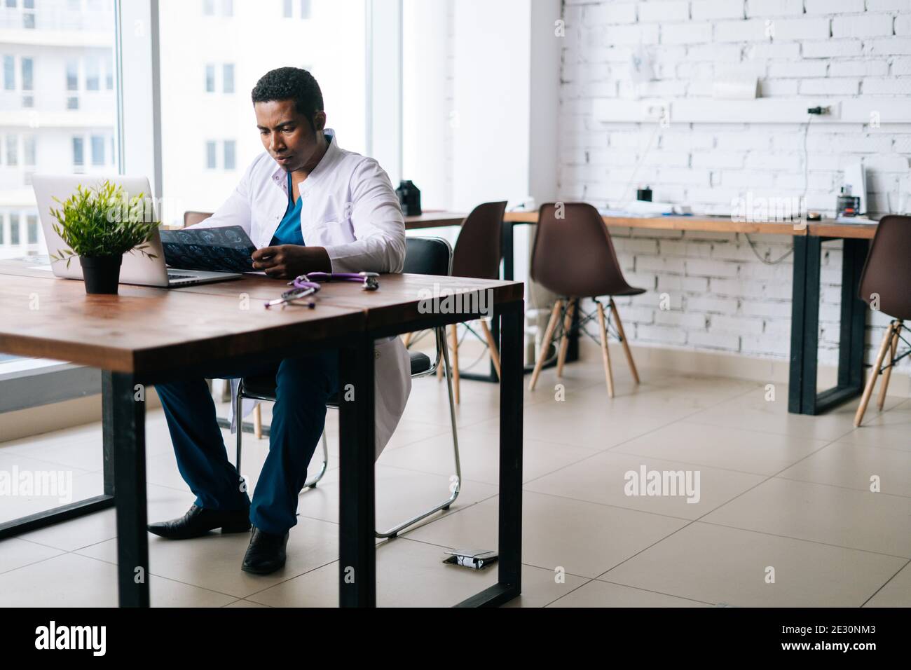 Wide shot of African American black man doctor examining MRI brain scan ...