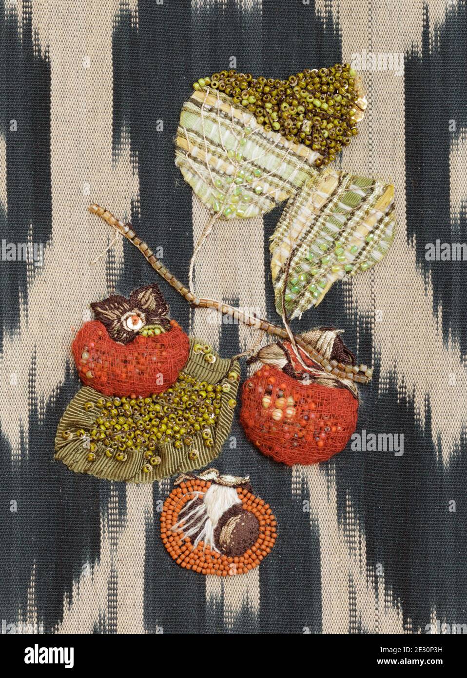 Couture embroidery of persimmon on ikat fabric. Still life with fruits ...