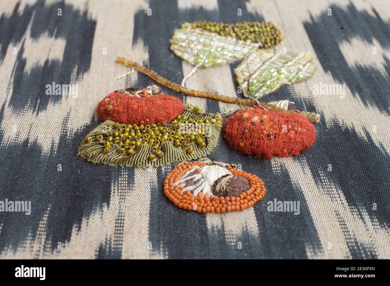 Couture embroidery of persimmon on ikat fabric. Still life with fruits ...