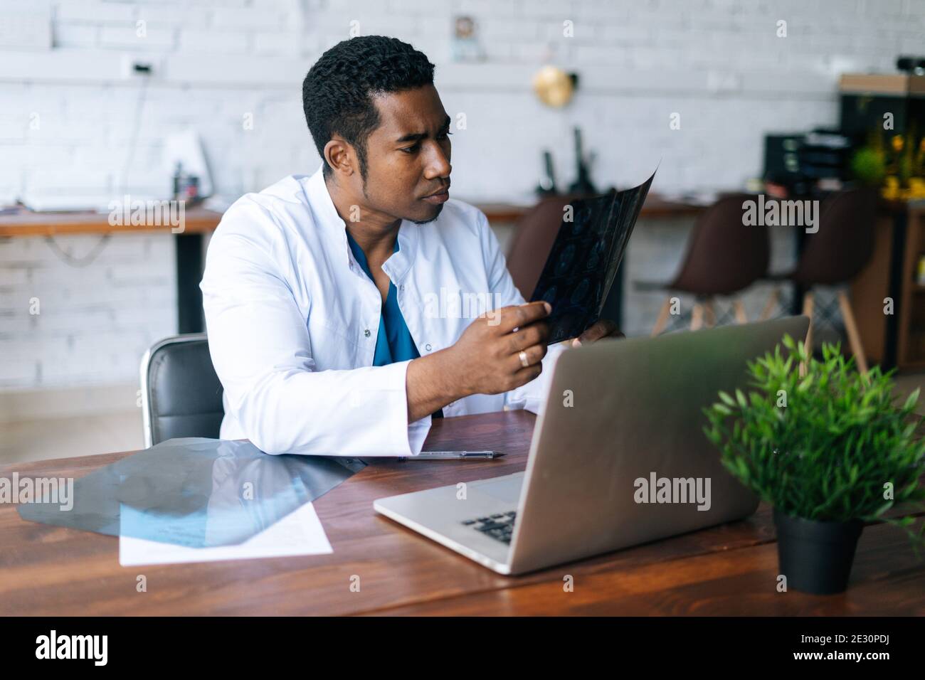 African American black man doctor looking at MRI brain scan image while ...