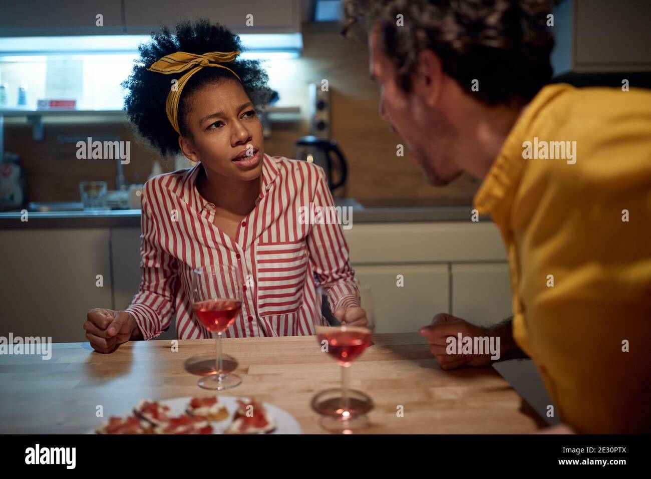 A young couple arguing while eating in a tense atmosphere at the ...