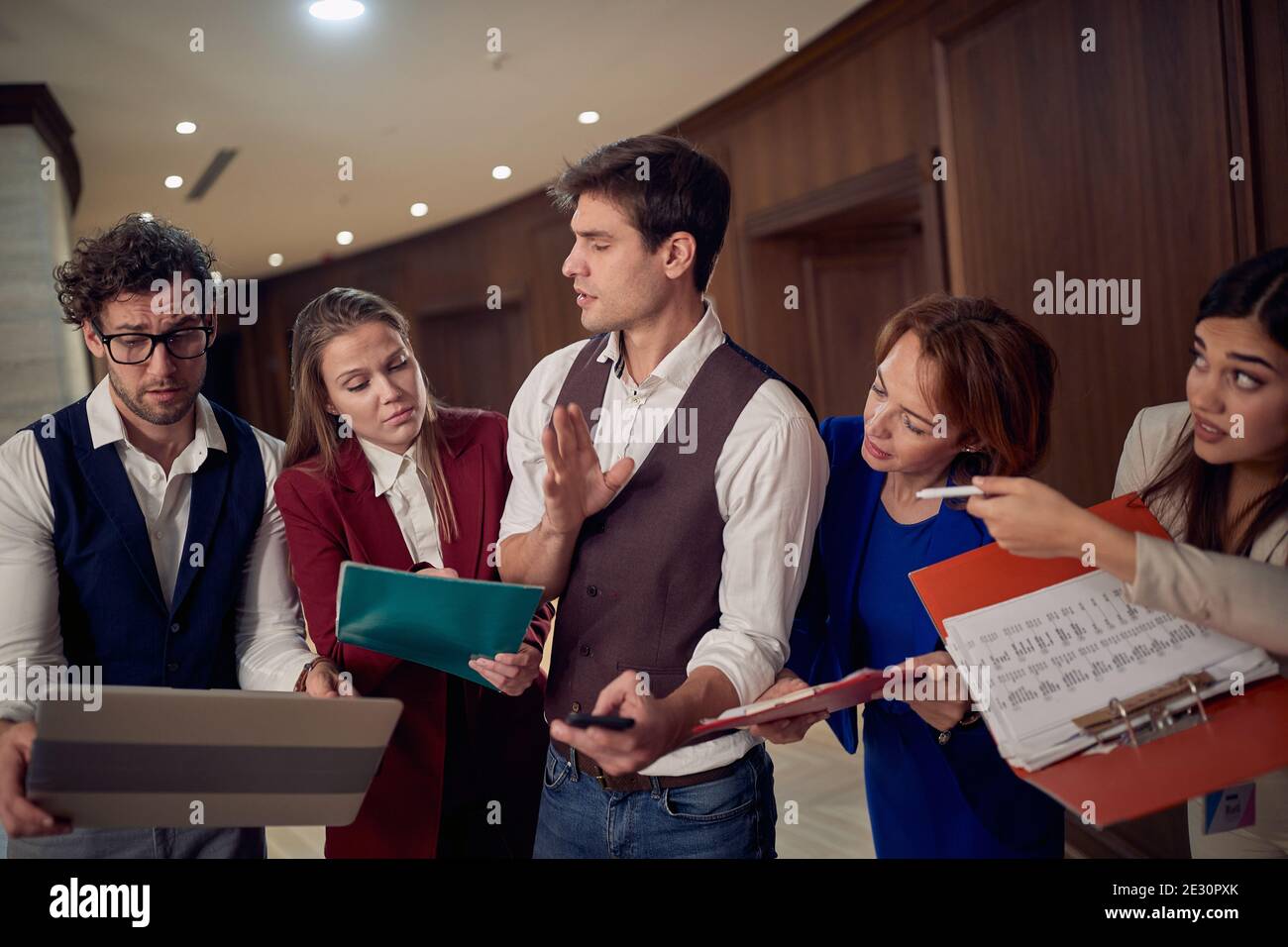 A male manager having a briefing with his team in a working atmosphere ...